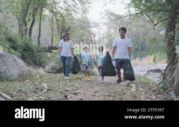 A group of Asian volunteer families give their thumbs up after ...