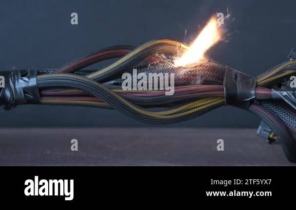 The wiring is burning and sparking on a dark background. A short ...