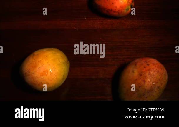 This is the stop motion animation footage of rotating mangoes on table ...