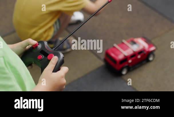 Boys play race with toy cars on playground. Preschooler operates red ...