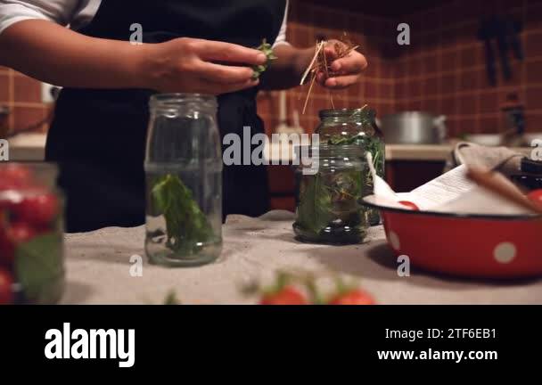Beautiful female chef, skilled housewife in white cap and black apron ...