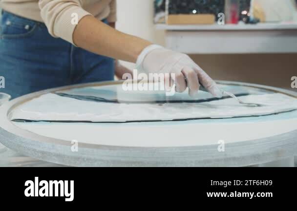 Young Woman Flattening The Surface Of A Round Epoxy Resin Art Object
