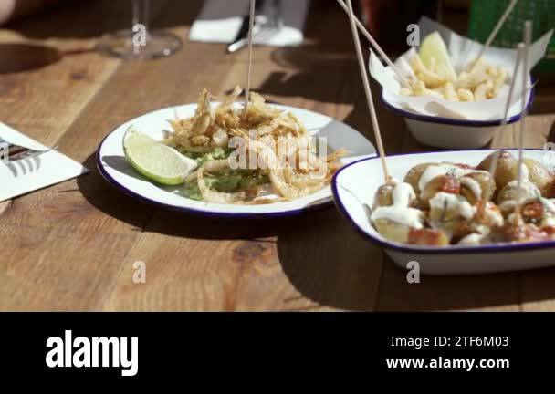 Video of close up of group of friends eating different plates of food ...