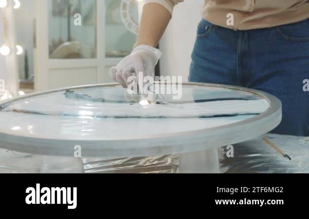 Young Woman Flattening The Surface Of Epoxy Resin Art Object Using A