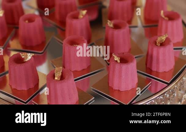 pink mousse mini light desserts with gelatin on gold stands on the ...