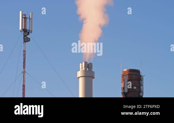 The chimney from the factory emits dirty smoke, there is an old red ...