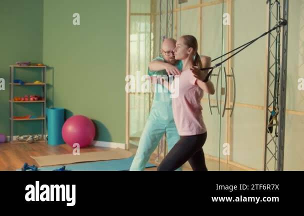 A Physiotherapist Helps a Girl do Exercises to Relieve her Back Pain ...