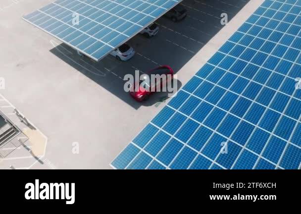 Aerial red electric car on rooftop parking with solar panels. Zero ...