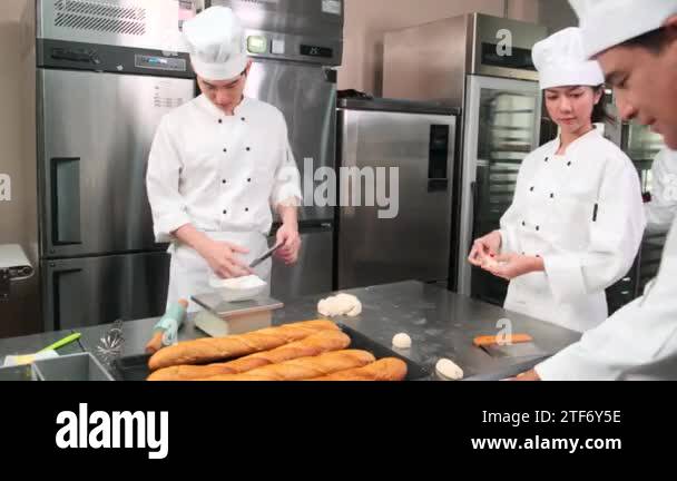 Multiracial professional gourmet team, four chefs in white cook ...