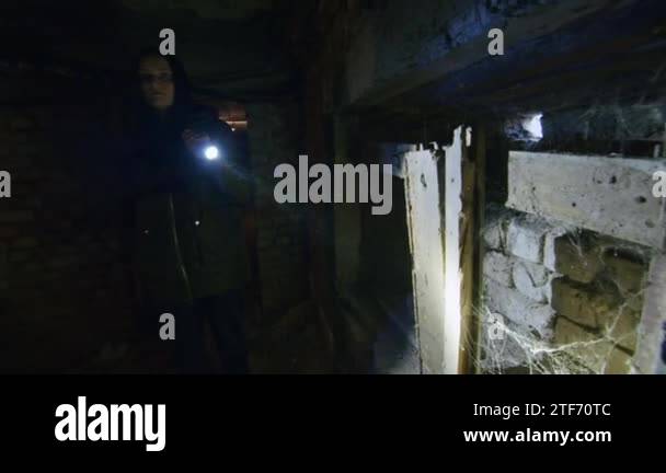 a girl in a terrible state searches a scary basement to find a possible ...