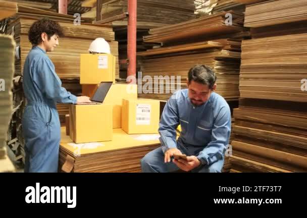 Two safety uniform workers and colleagues use laptop and mobile phone ...