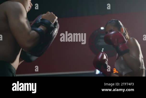 Asian beautiful young woman exercise with trainer at boxing gloves and ...