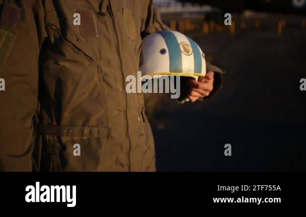 Military Fighter Pilot holding his Helmet looking at the Horizon during ...