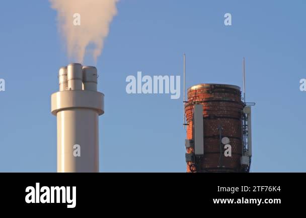 The chimney from the factory emits dirty smoke, there is an old red ...