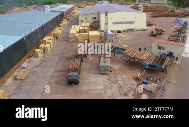 Automated log sorting at a sawmill, aerial view. Crane unloads logs to ...