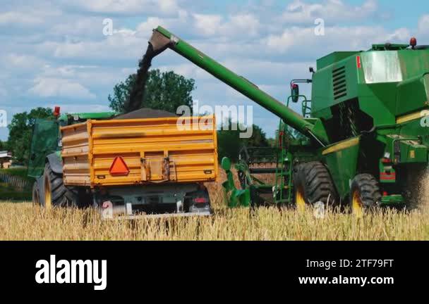 Two agricultural machines - combine harvester and tractor with a ...