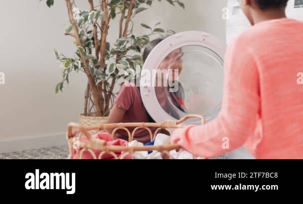 Fooling around, joking, playing while doing household chores, woman and ...