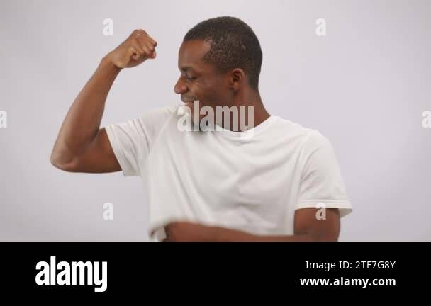 African American man demonstrates power and strength showing muscles ...
