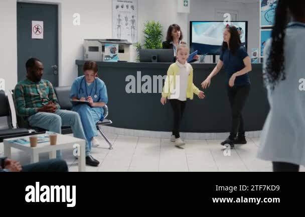 Diverse group of people in busy waiting room lobby with reception desk ...