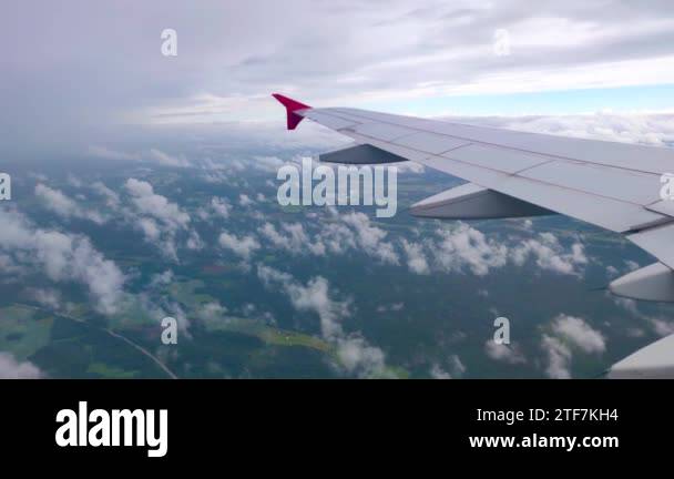 Airplane flying. Wing of an airplane flying above the clouds with ...
