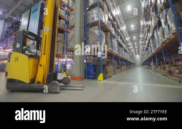 Worker on a modern forklift. Working in a large modern warehouse ...