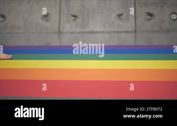 Slow motion of feet walking barefoot on LGBT rainbow colored crosswalk ...
