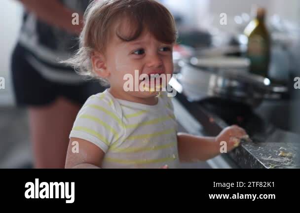 Upset baby covered with flour at kitcen. Angry child hhaving a tantrum ...