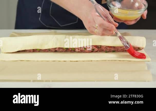 smearing egg pie. Cooking stuffed pies. woman smearing dough with ...