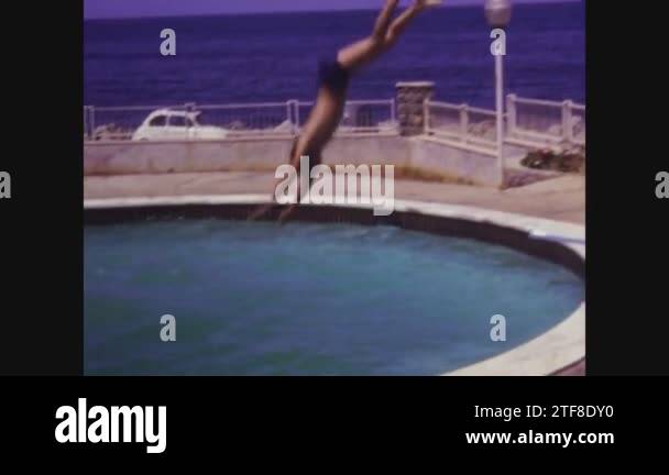 PIANO BATTAGLIA, ITALY JULY 1971: Boys jump into the pool from the ...