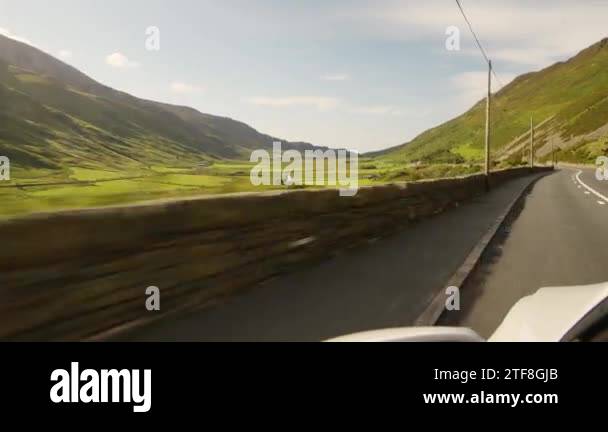 Driving through lush countryside valley and mountains in Snowdonia ...