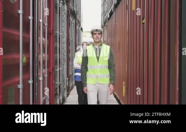 Group of multiracial workers in safety uniforms and hardhats walk in a ...
