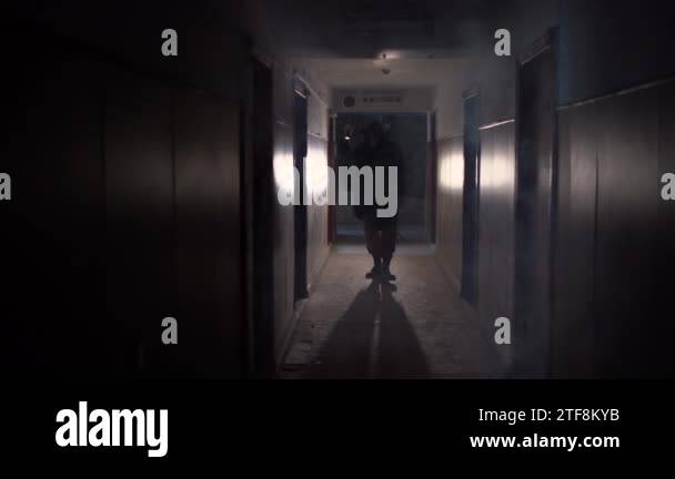 Man in respirator gas mask, hood and camo pants walk on the inside of ...