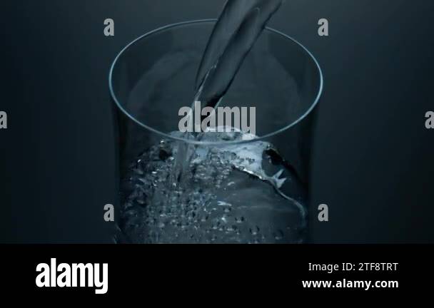 Pure water pouring cup closeup. Refreshing liquid bubbling filling ...