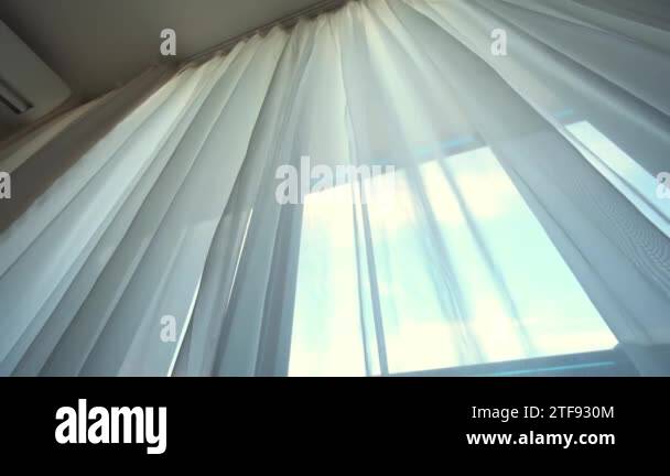 wind blows through open window in room. Swinging curtains by window in ...