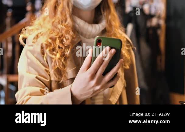Woman in medical mask showing smartphone with International Vaccination ...