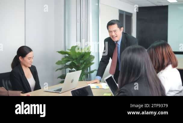 Angry asian boss yelling at colleagues during a meeting with his team ...