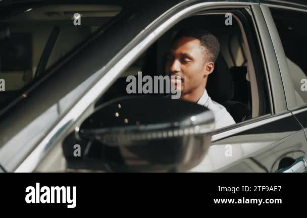 Man sitting inside his luxury car with keys in hands. Handsome man ...