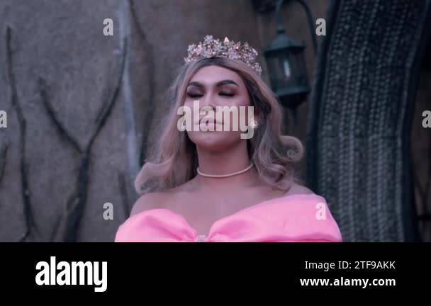 A Queen standing in front of her palace while wearing a pink dress and ...