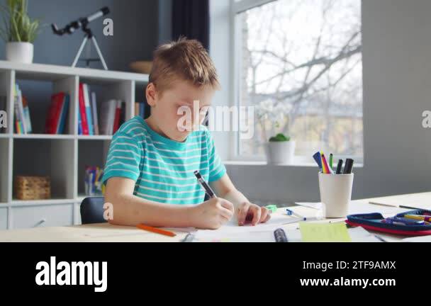 Boy is Doing his Homework at the Table. Cute Child is Learning at Home ...