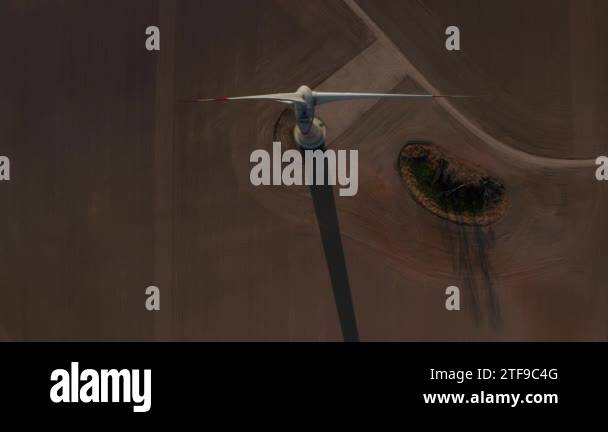Top down shot of wind turbine in middle of field. Spinning rotor ...