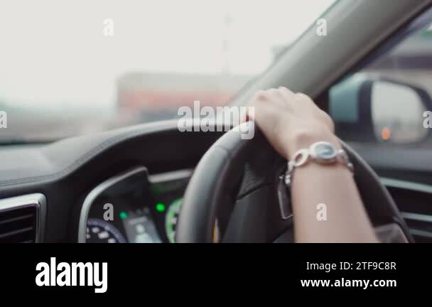 Unrecognizable female driver using left hand grabs on the steering ...