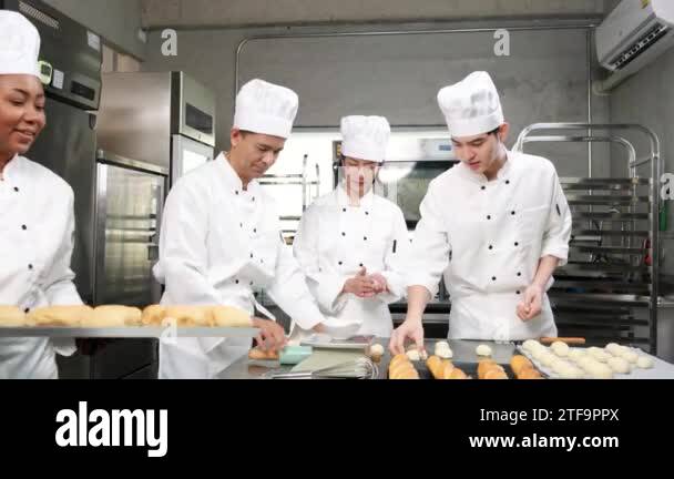 Multiracial professional gourmet team, four chefs in white cook ...