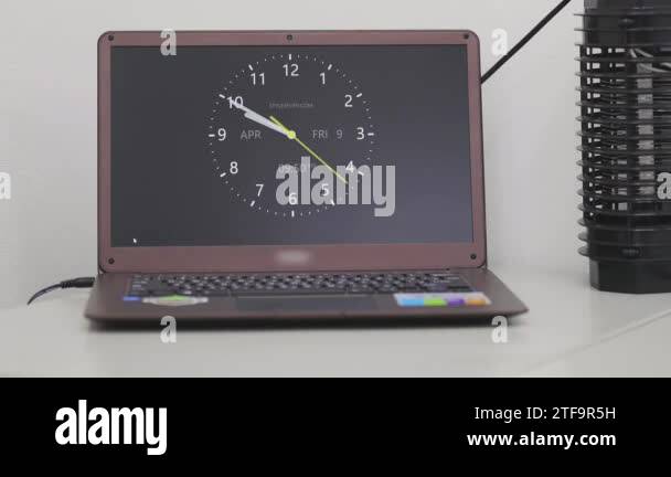 Clock with arrow on the laptop screen. Old clock shows time on laptop ...