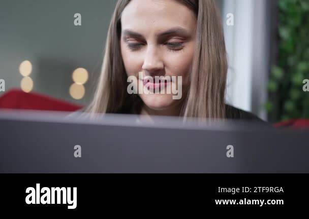 Concentrated young woman in front of laptop computer working remotely ...