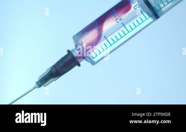 Close Up of Injection Liquid In Syringe Blue Background. Medication ...