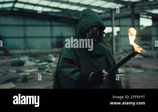 Soldier man with gas mask in a destroyed building by war with torch ...