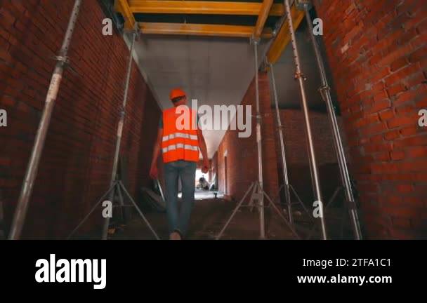 Builder inside the house. The builder goes inside the building under ...