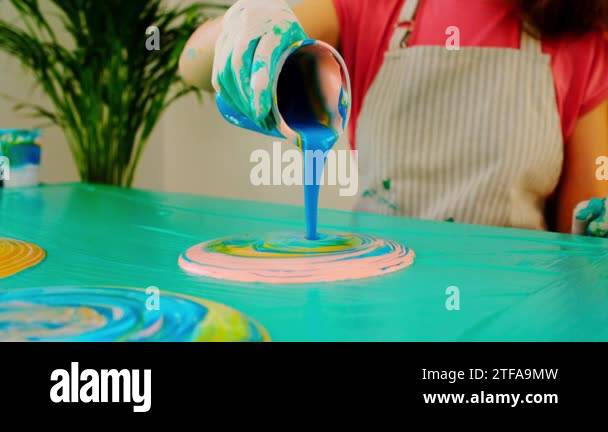 Fluid art technique. Female artist works on abstract fluid art painting ...