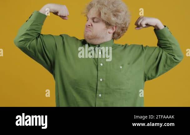 Portrait of obese guy raising arms demonstrating muscles kissing biceps ...