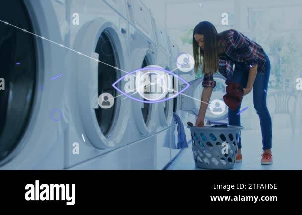 Video of biracial young woman putting clothes in washing machine with ...